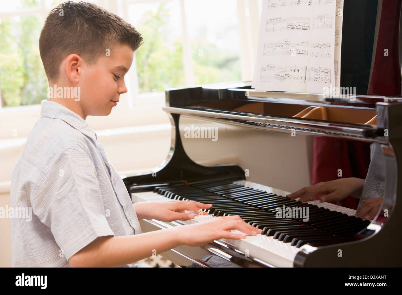 Smiling boy playing piano hi-res stock photography and images - Alamy