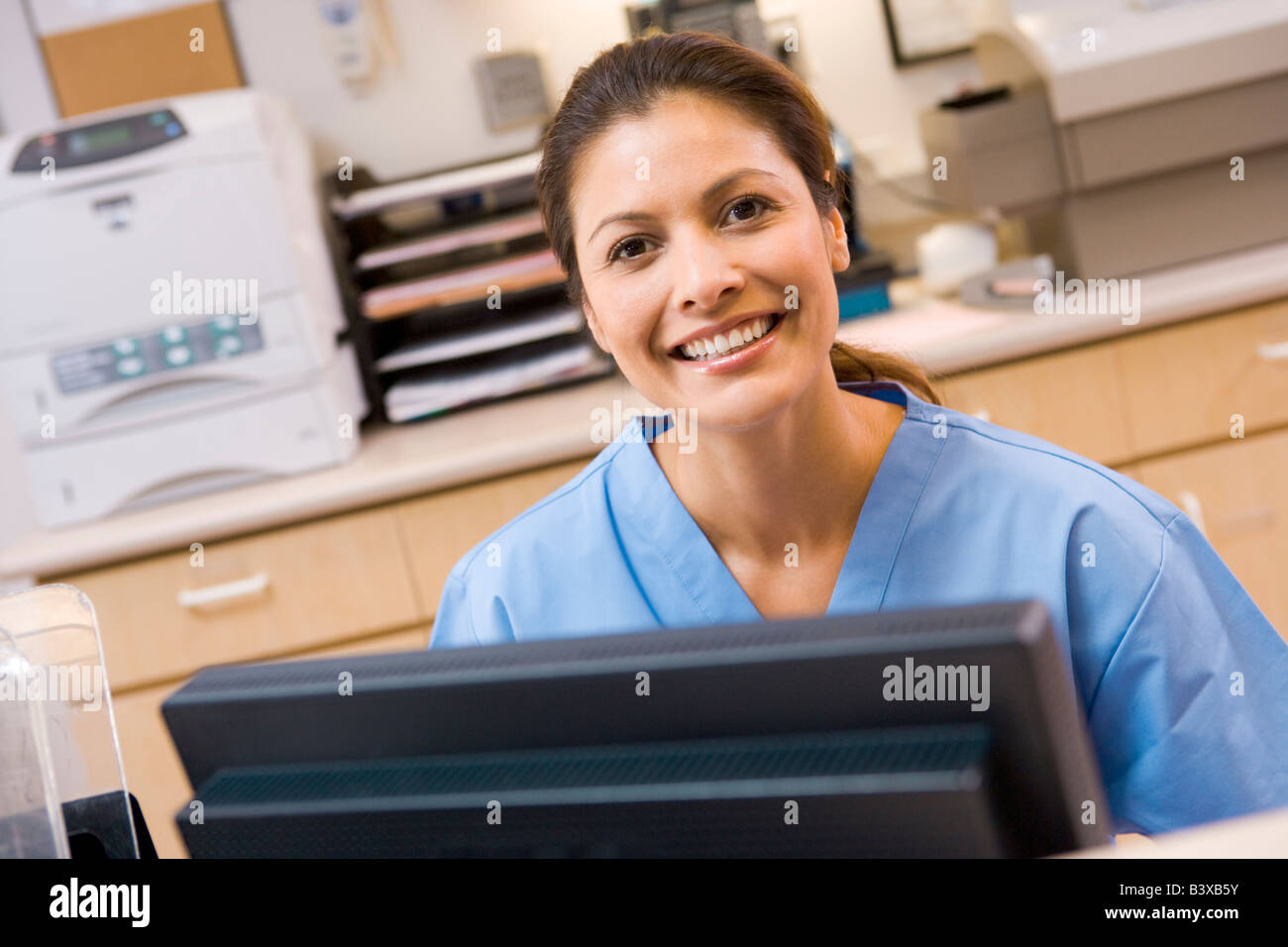 A Nurse Sitting At A Computer At The Reception Area Of A Hospital Stock ...