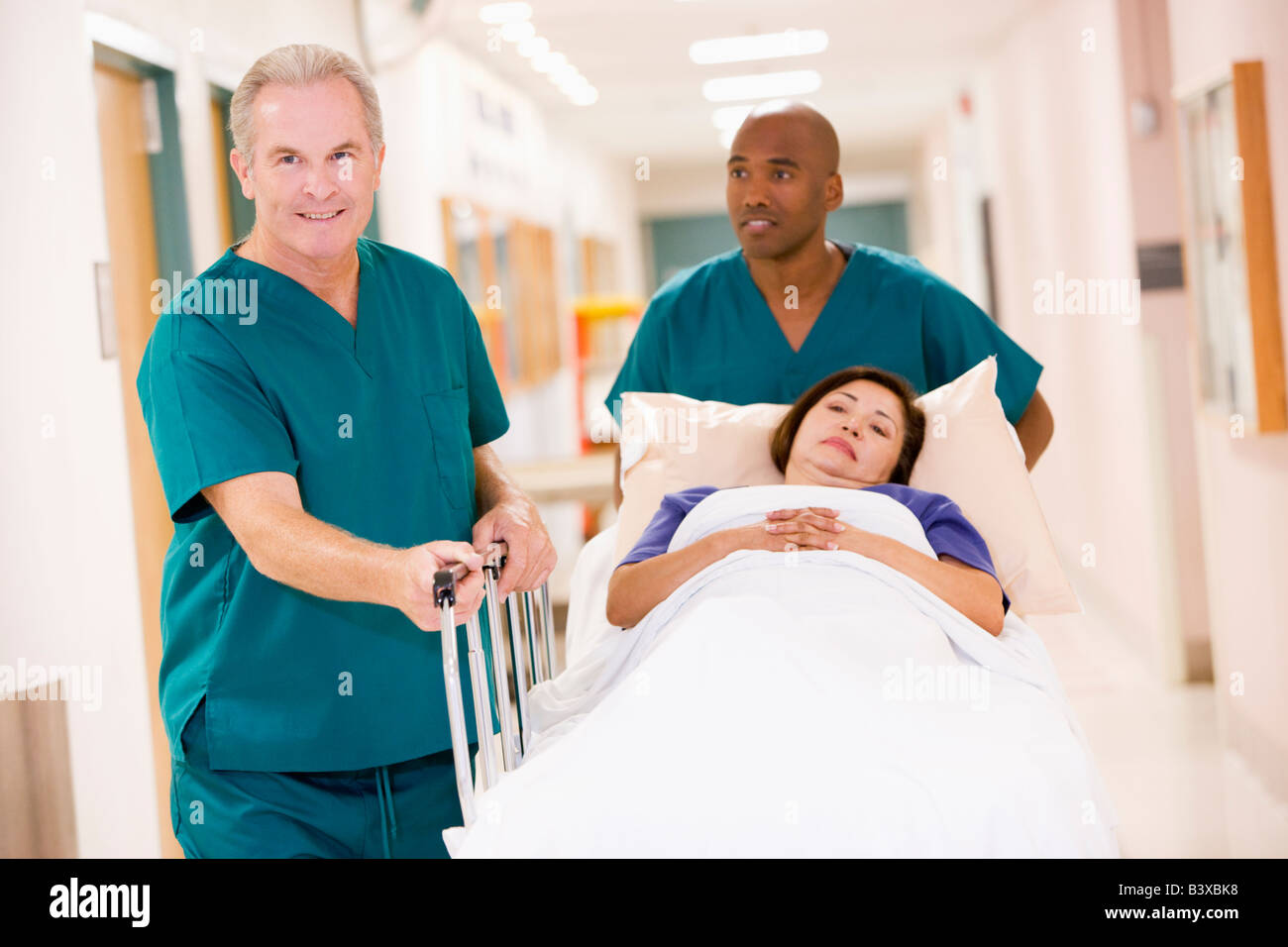 Two Orderlies Pushing A Woman In A Bed Down A Hospital Corridor Stock ...