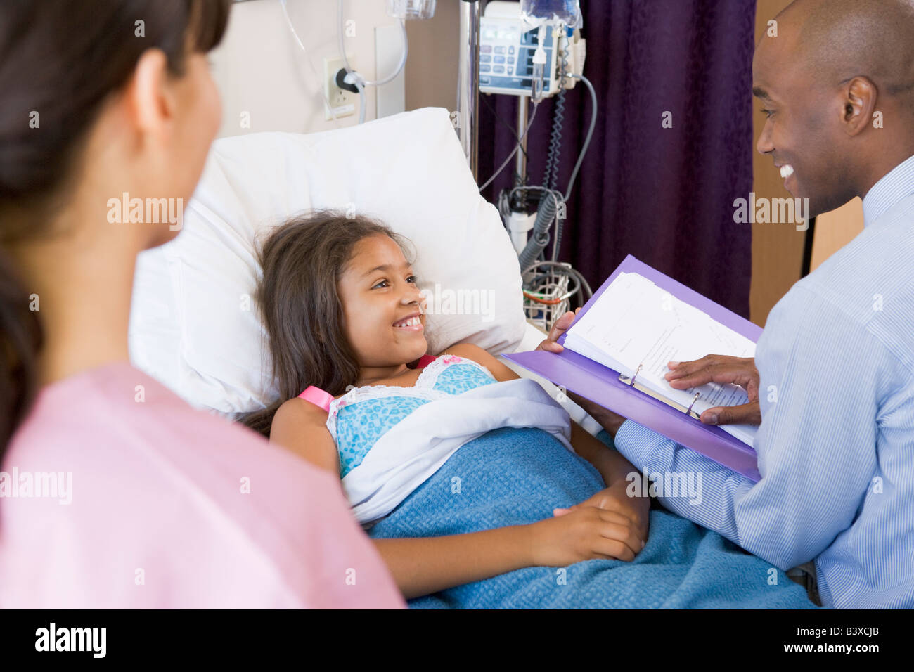 Doctor Making Notes On Patient Stock Photo - Alamy