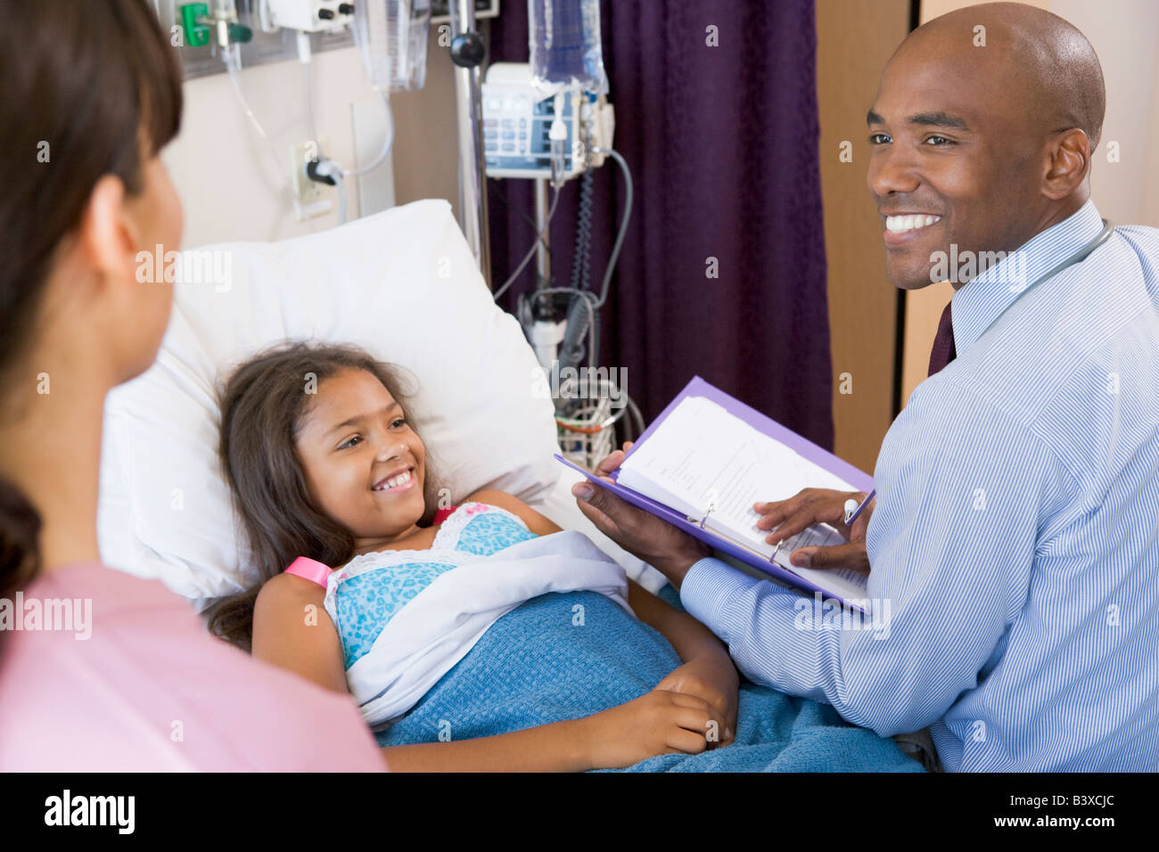Doctor Making Notes On Young Girl Stock Photo - Alamy