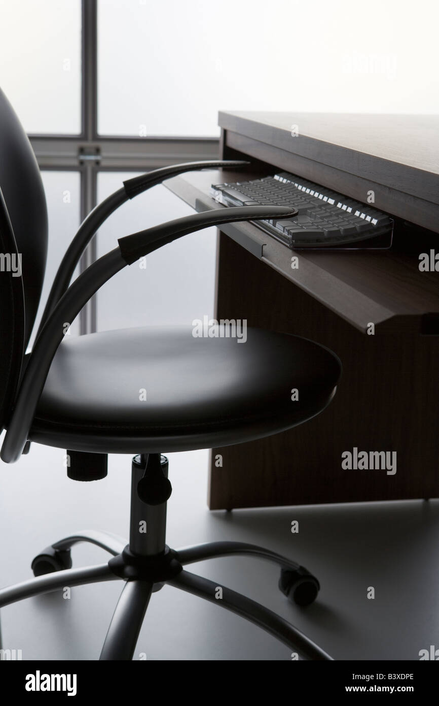 Empty Office Chair And Desk With Computer Keyboard Stock Photo - Alamy