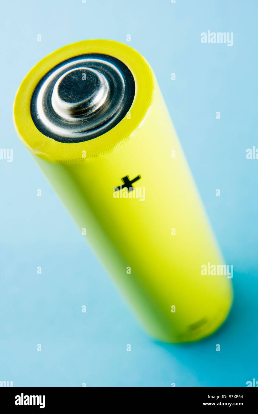 A Yellow Battery Against A Blue Background Stock Photo - Alamy