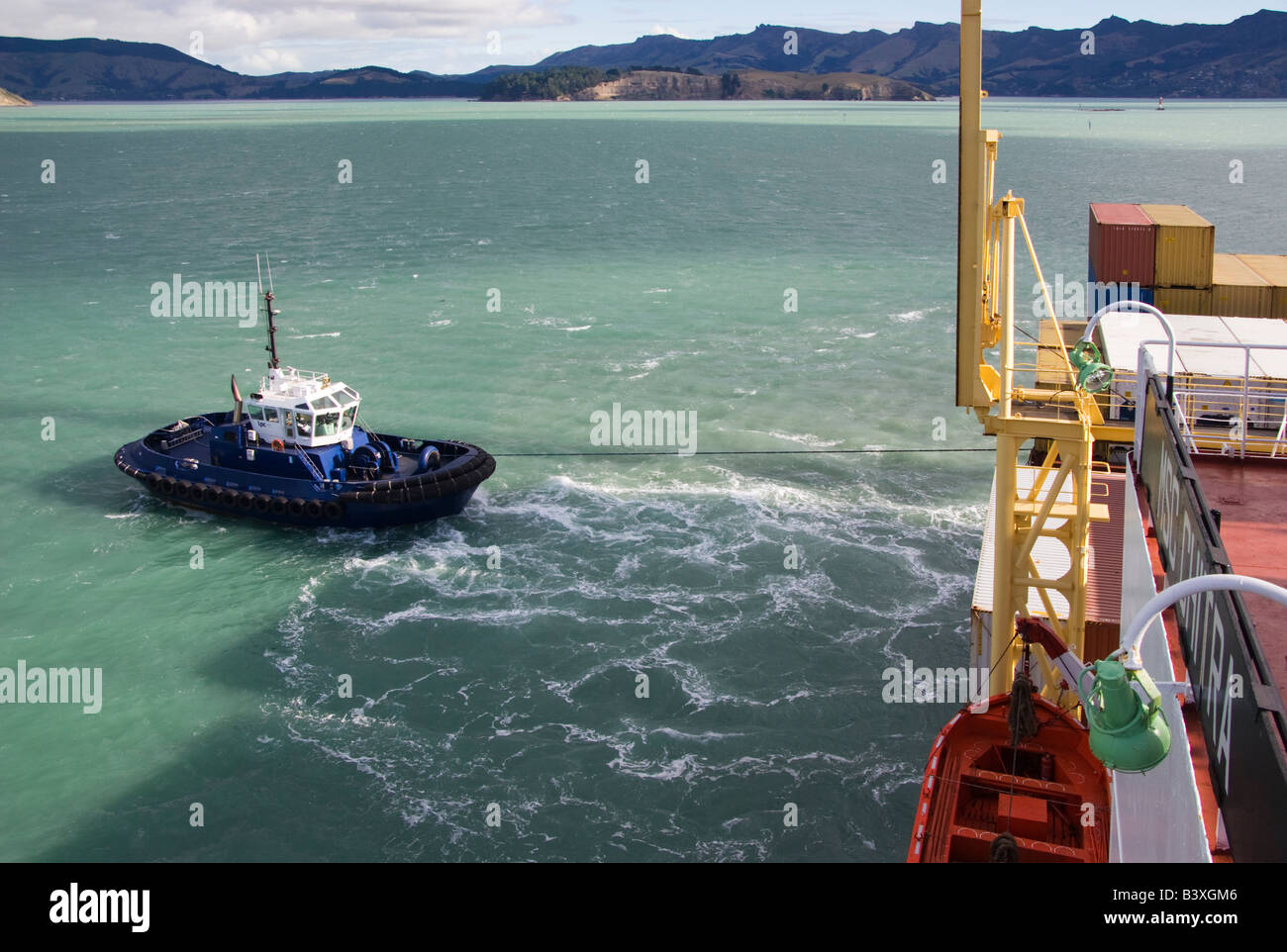 A tug pulls while assisting a ship in port, as seen from the bridge of ...