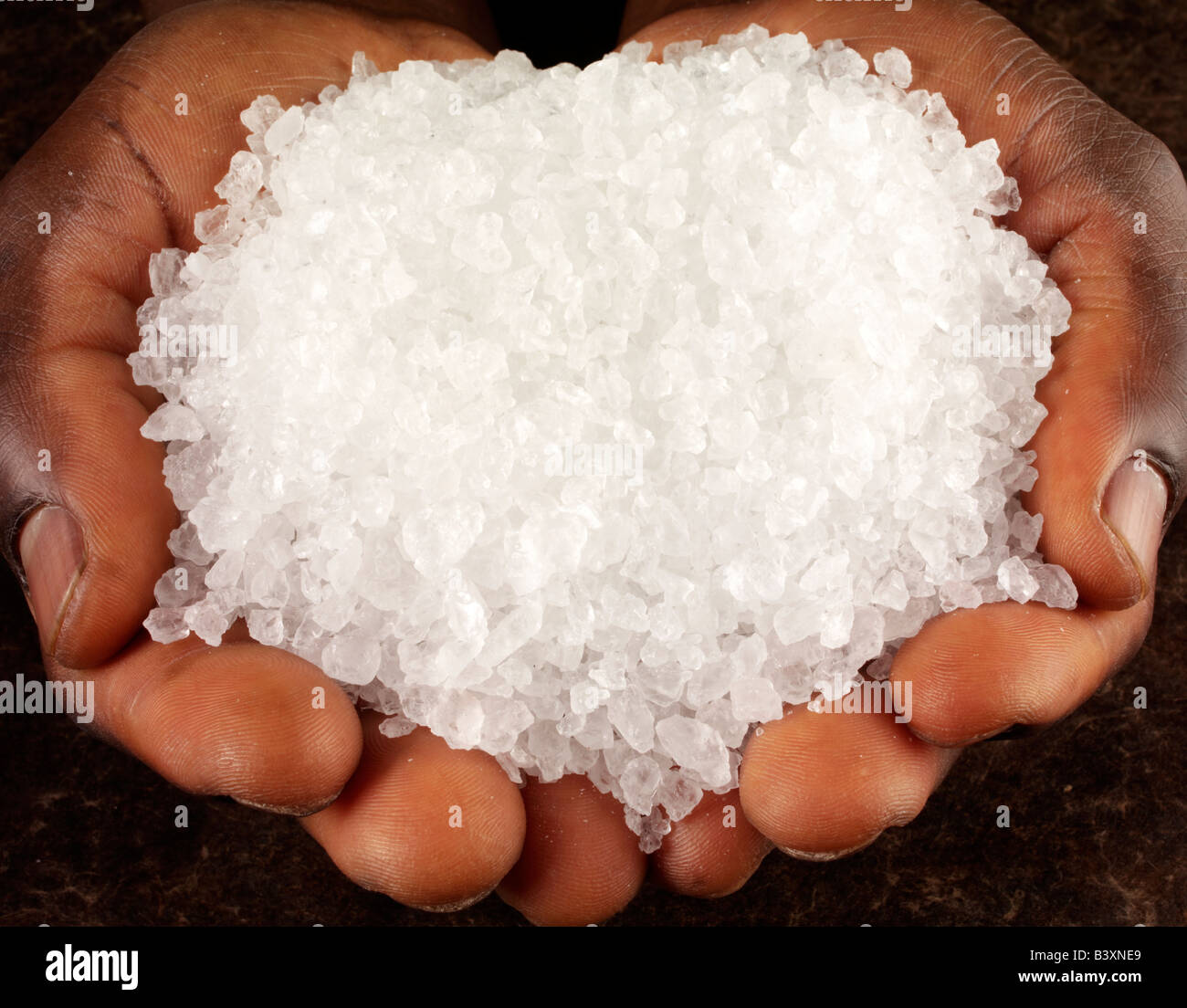 MAN HOLDING ROCK SALT GRANULES Stock Photo - Alamy