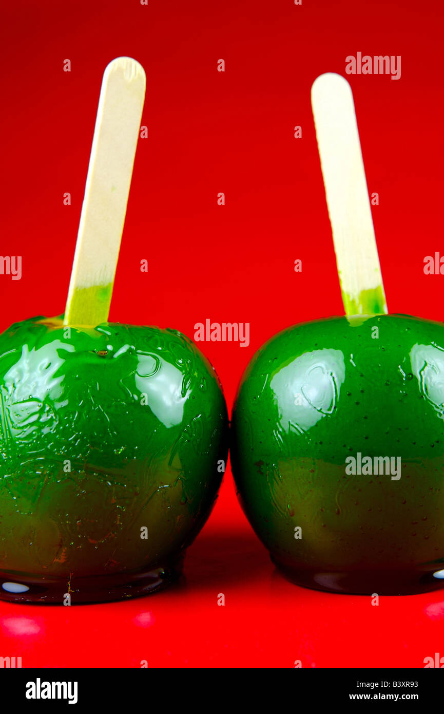 Toffee apples isolated against a red background Stock Photo - Alamy