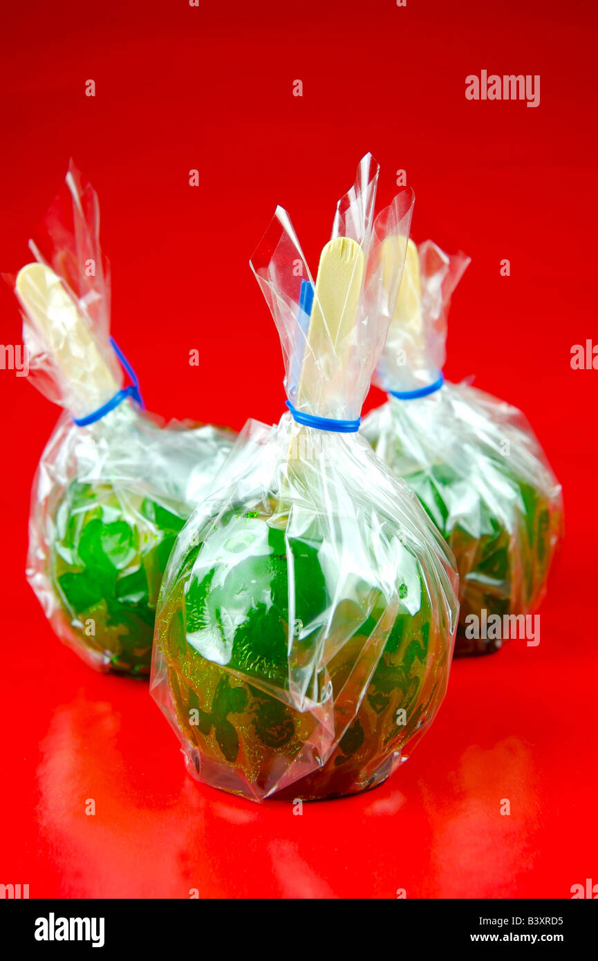 Toffee apples isolated against a red background Stock Photo - Alamy