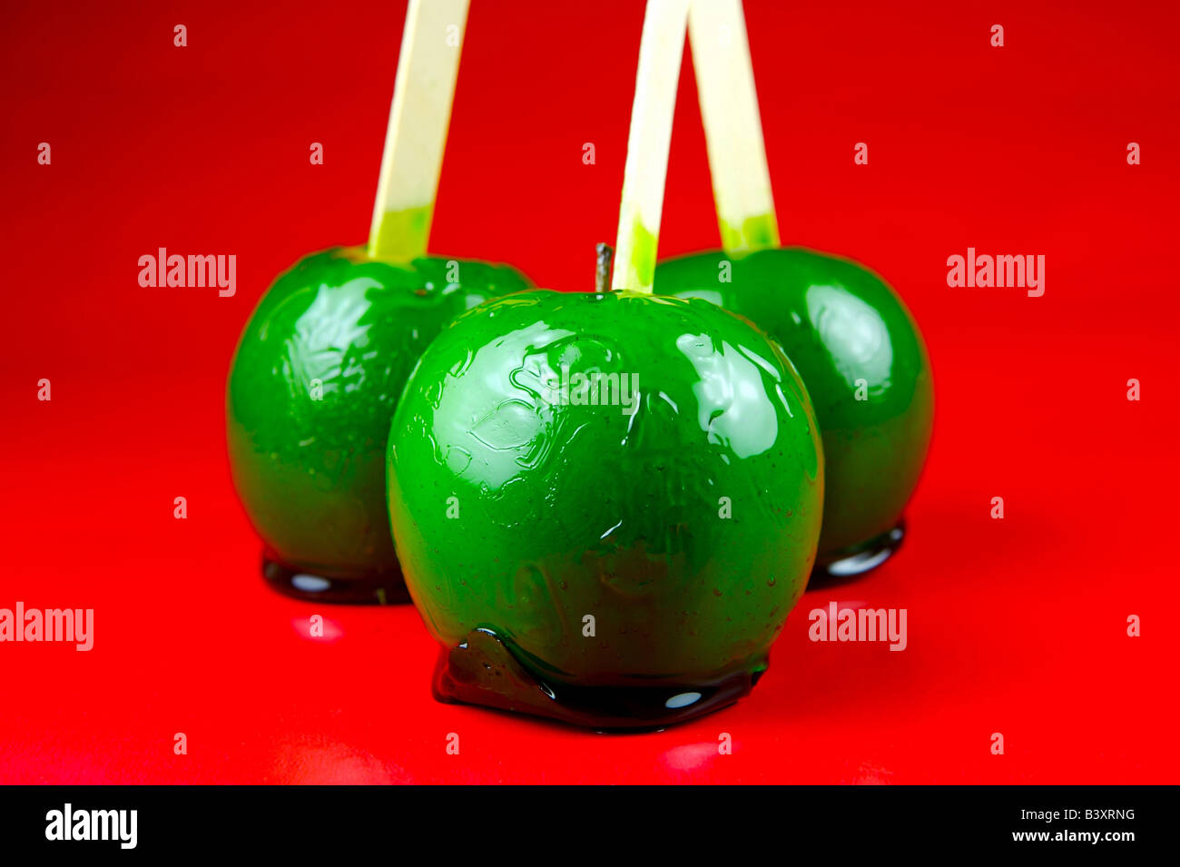 Toffee apples isolated against a red background Stock Photo - Alamy