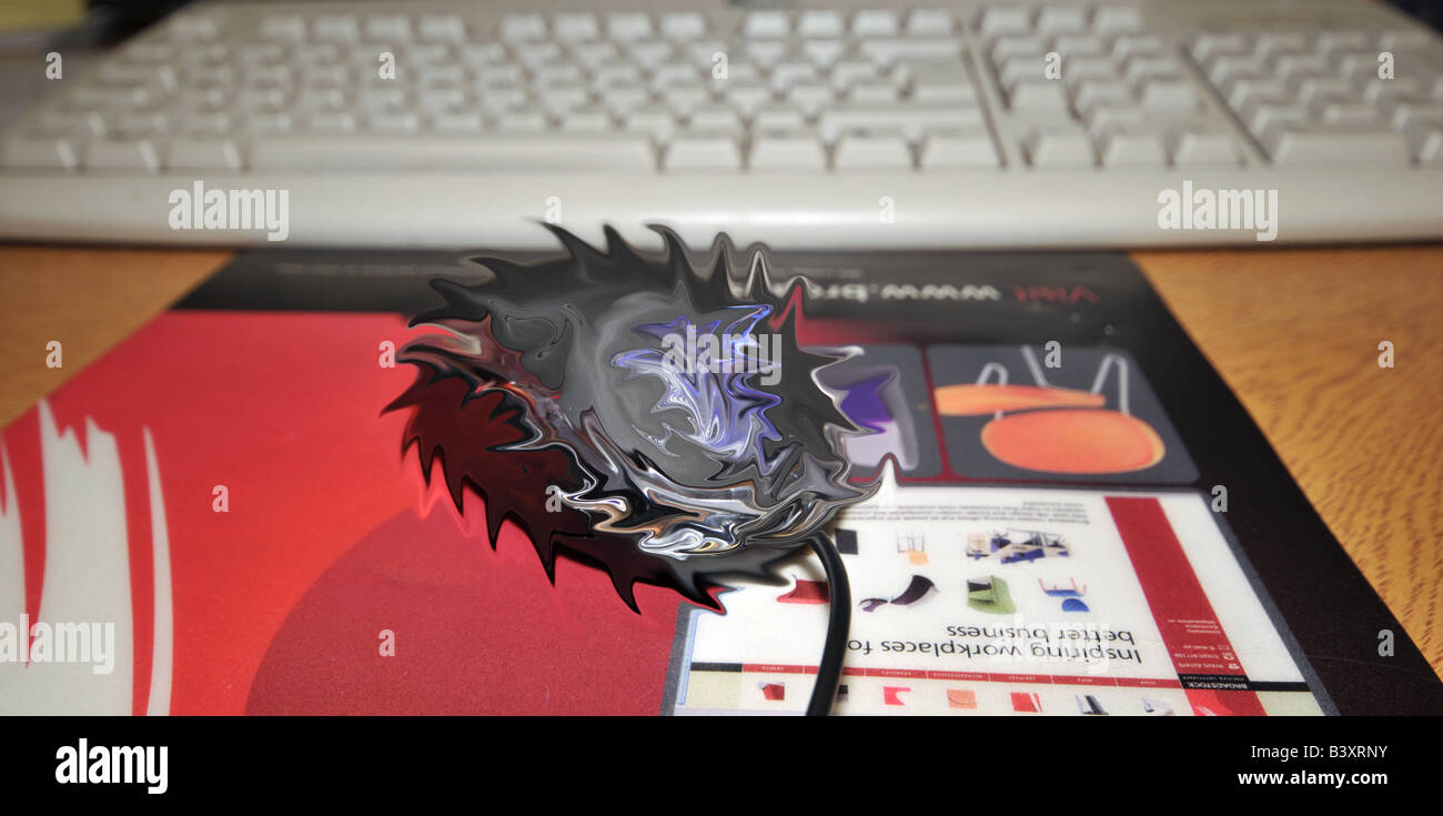 distorted computer/IT mouse on red mousemat with keyboard in background ...