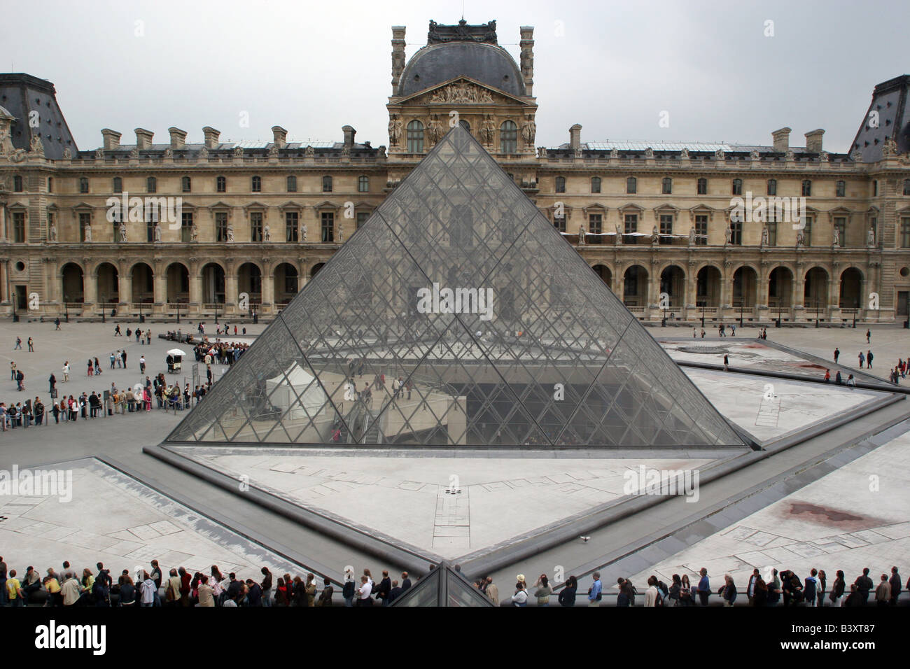 People standing in line outside the Louvre and the Louvre Pyramid Paris ...