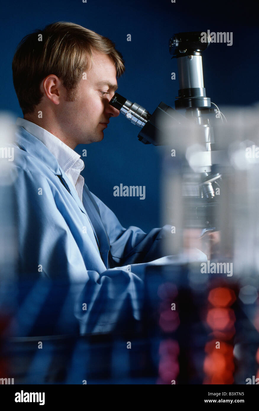 Technician checking water samples through a microscope in the quality ...