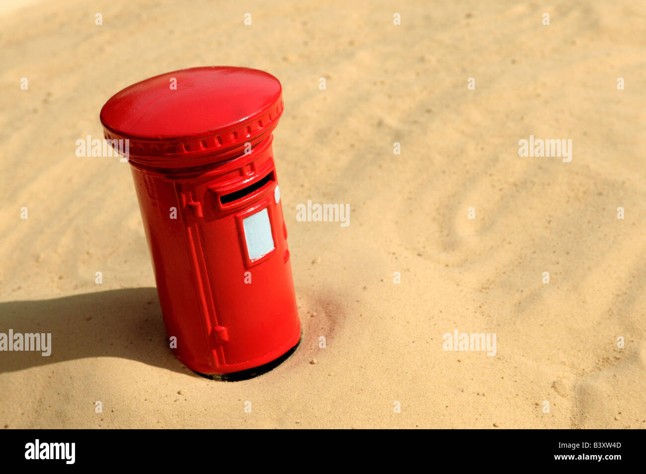 Red post box in sand Stock Photo - Alamy