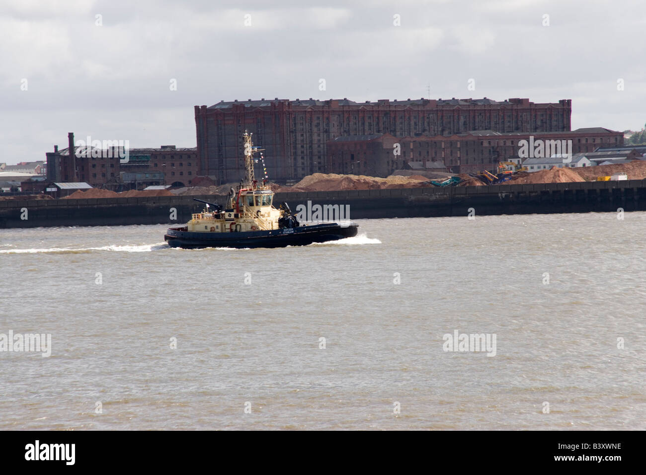 Tug boat going up the Mersey river with Liverpool behind shot from ...
