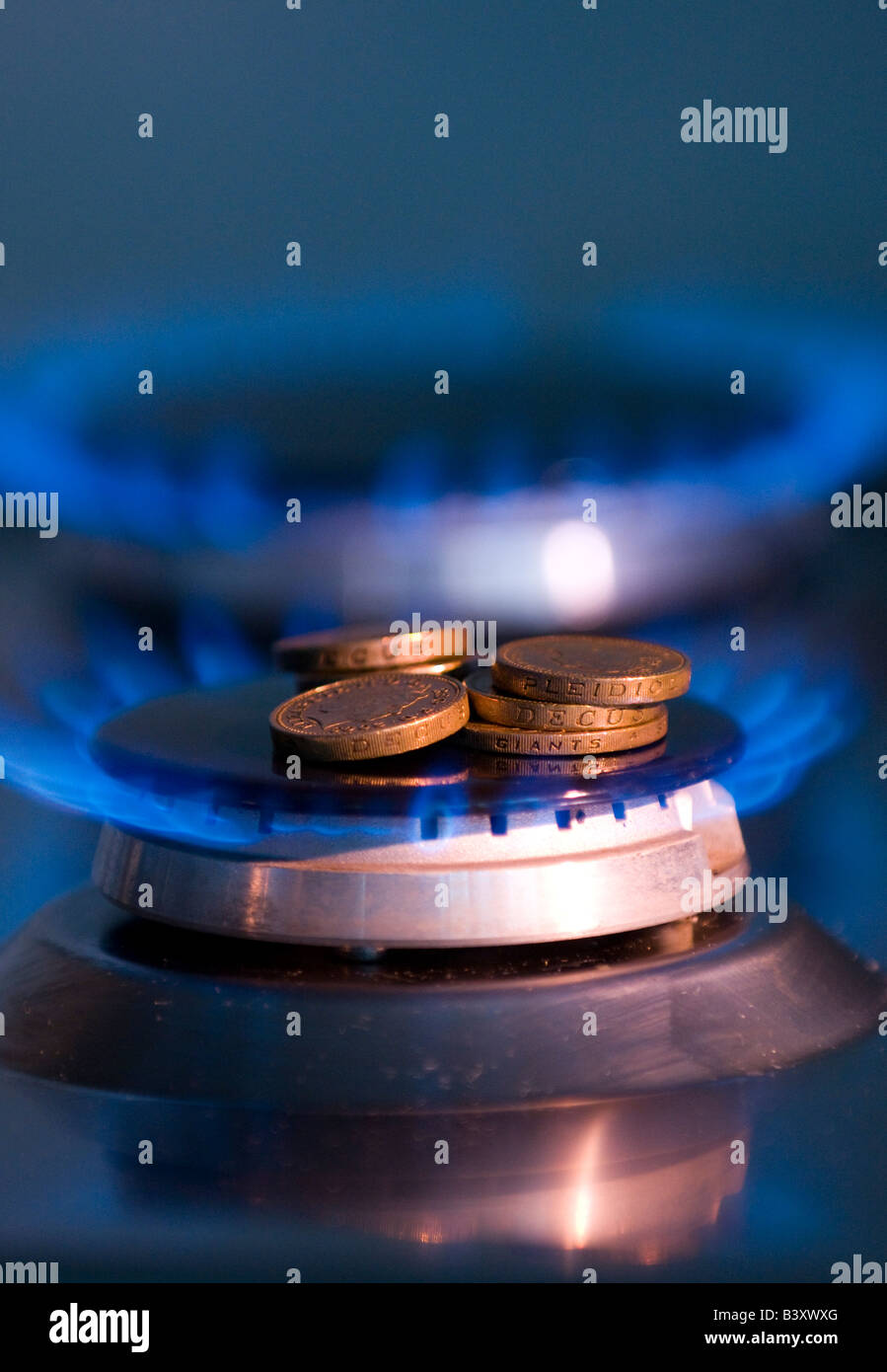 Stack of coins on a gas hob Stock Photo - Alamy