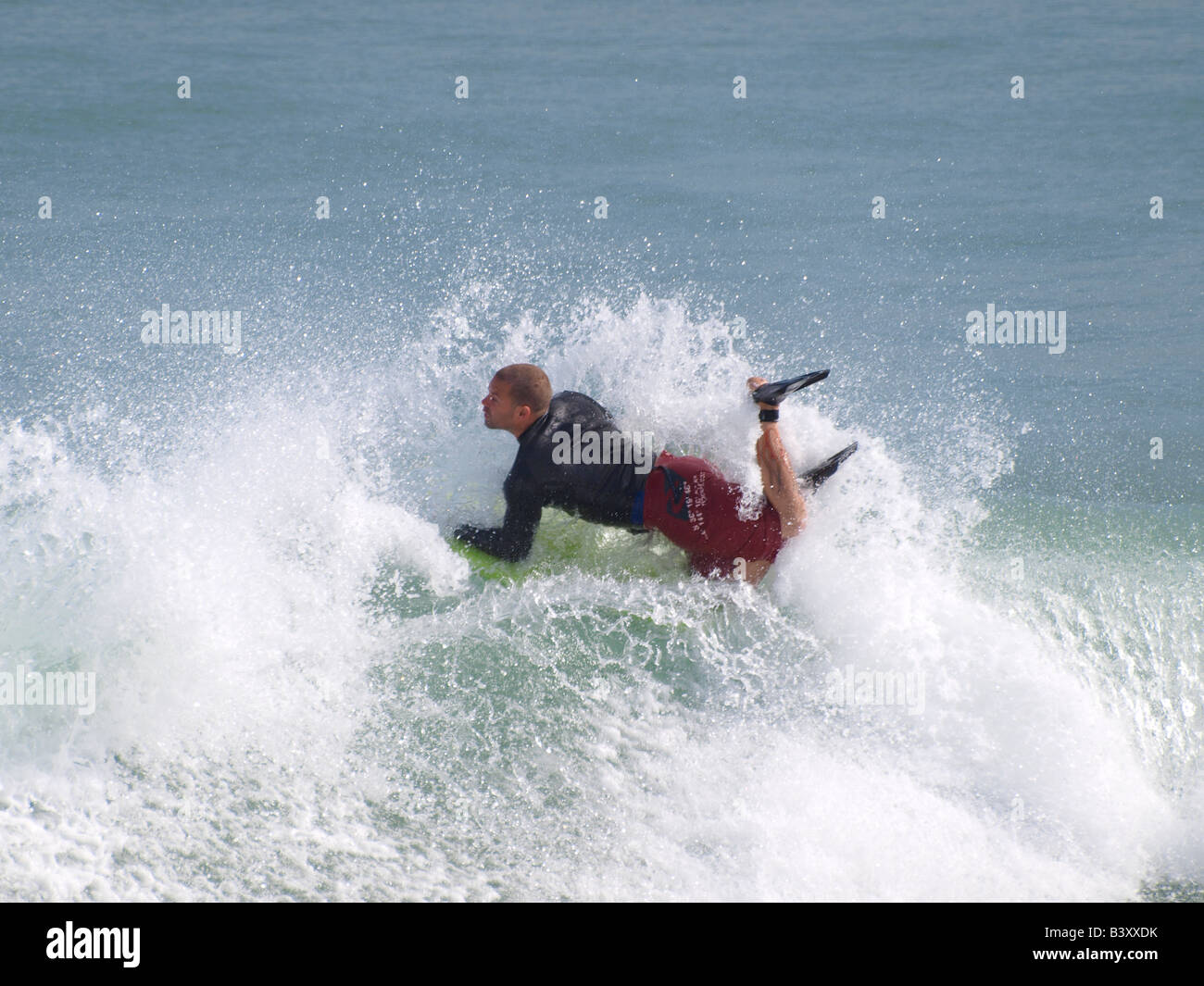Bodyboarder paddling through a breaking wave Stock Photo - Alamy