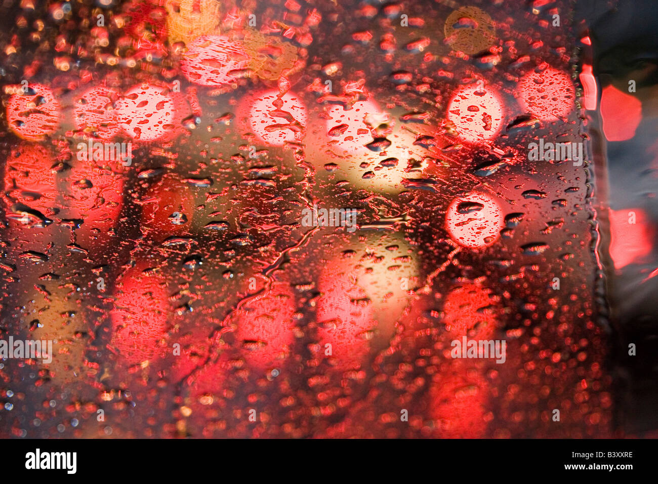 Lights from street cars reflect on a windshield during a rainy day ...