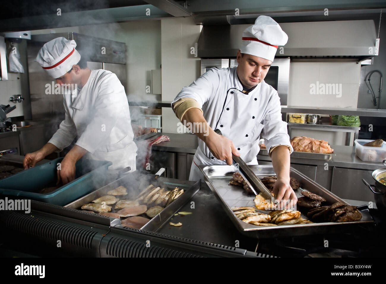Two chefs at work in a restaurant Stock Photo - Alamy