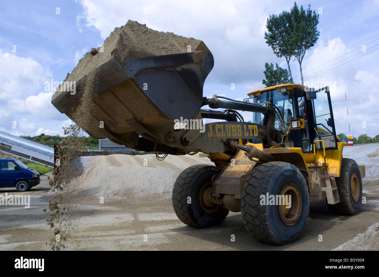 A loader tractor moves sand in the quarry Stock Photo - Alamy