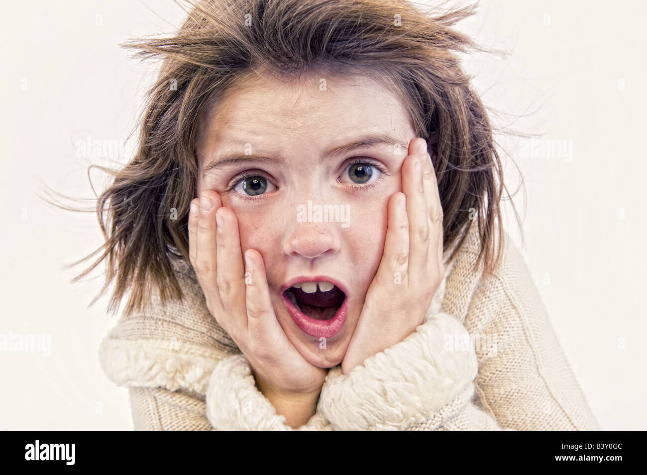Terrified young girl with hair flying isolated on white background ...