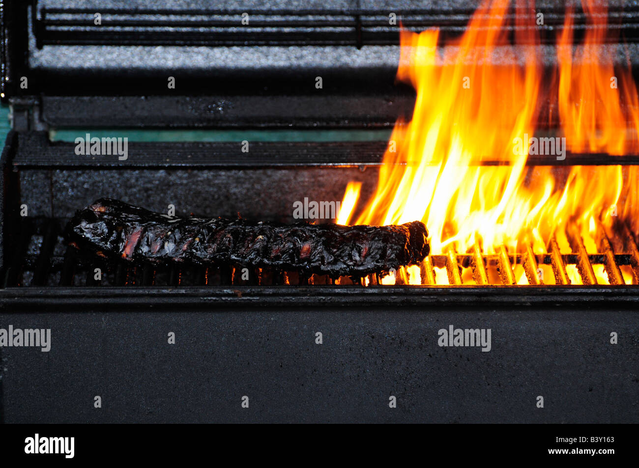 Ribs on fire on the grill Stock Photo - Alamy