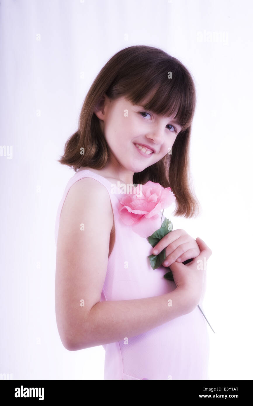 Young brunette girl holding single pink rose flower isolated on white ...