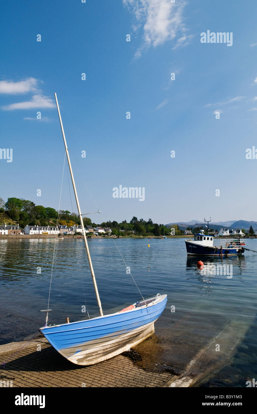 Small wooden sailboat sits sideways on stone boat ramp into Loch Carron ...