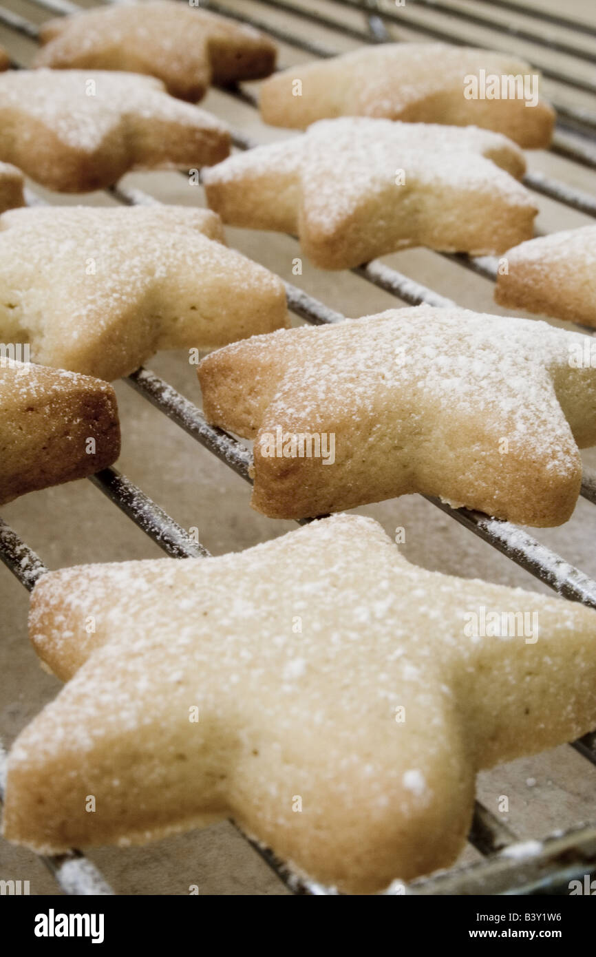Freshly baked biscuits on a cooling rack dusted with icing sugar Stock ...