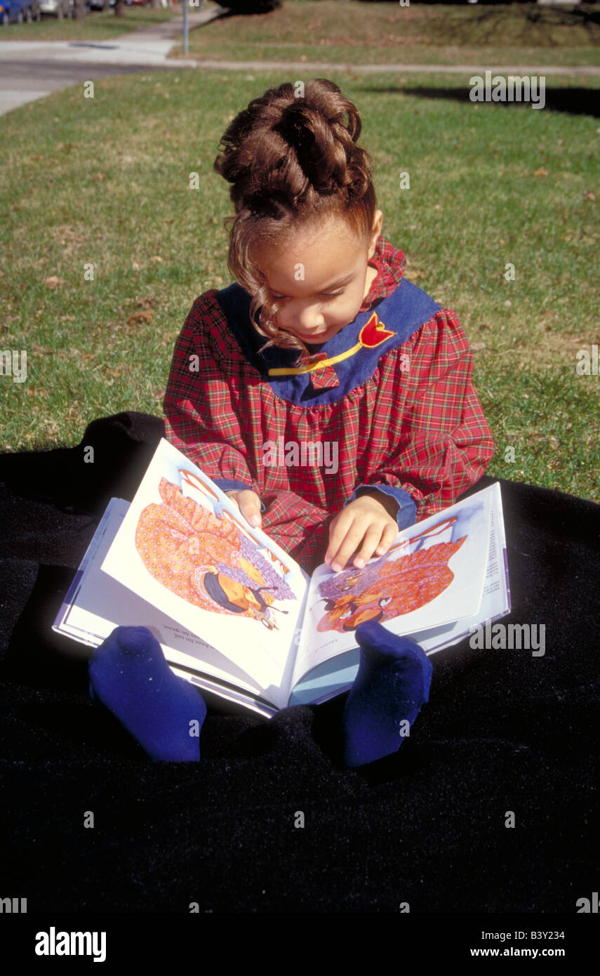 Black girl reading a book on the lawn. St. Paul, Minnesota Stock Photo ...