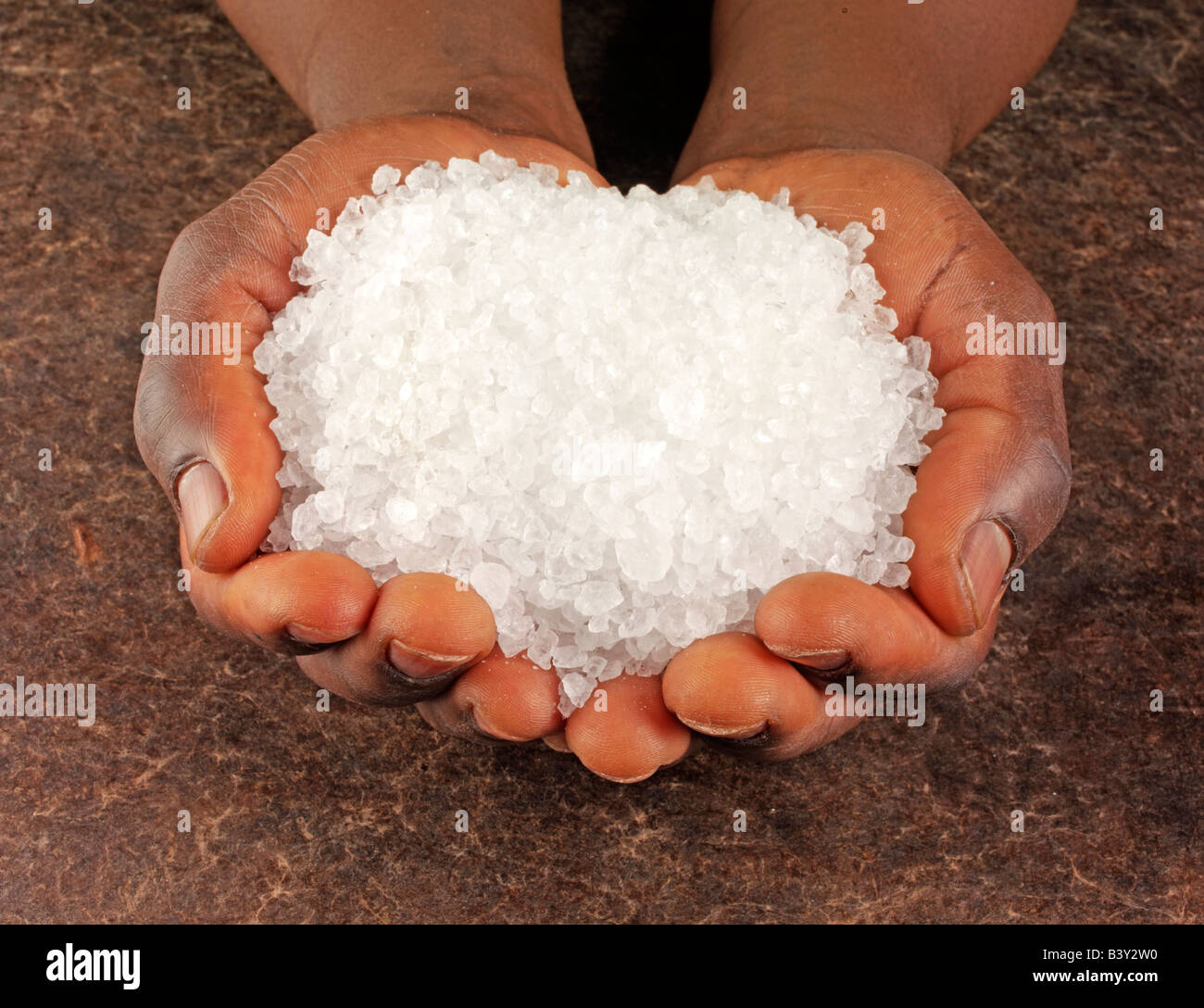 MAN HOLDING ROCK SALT GRANULES Stock Photo - Alamy