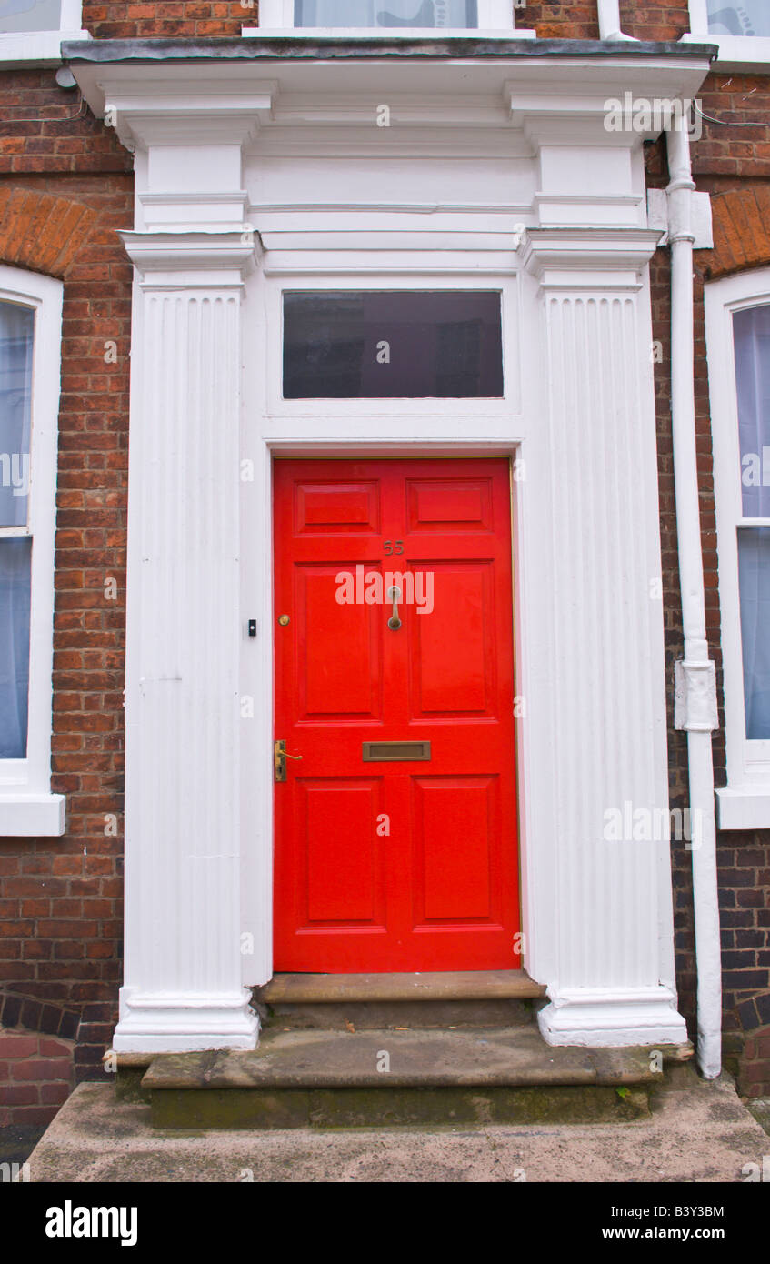 Red six panel front door with white pillars and glazed skylight of ...