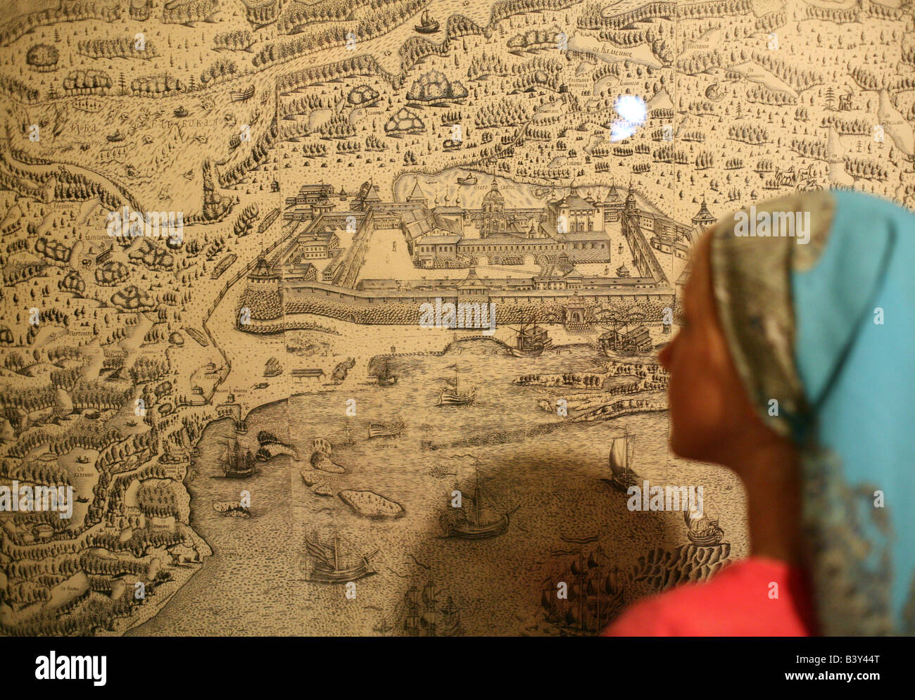 Young visitor looking at an ancient map of Solovetsky monastery in the ...