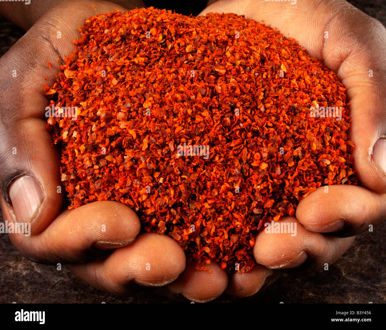 MAN'S HANDS HOLDING DRIED CHILLI FLAKES Stock Photo - Alamy
