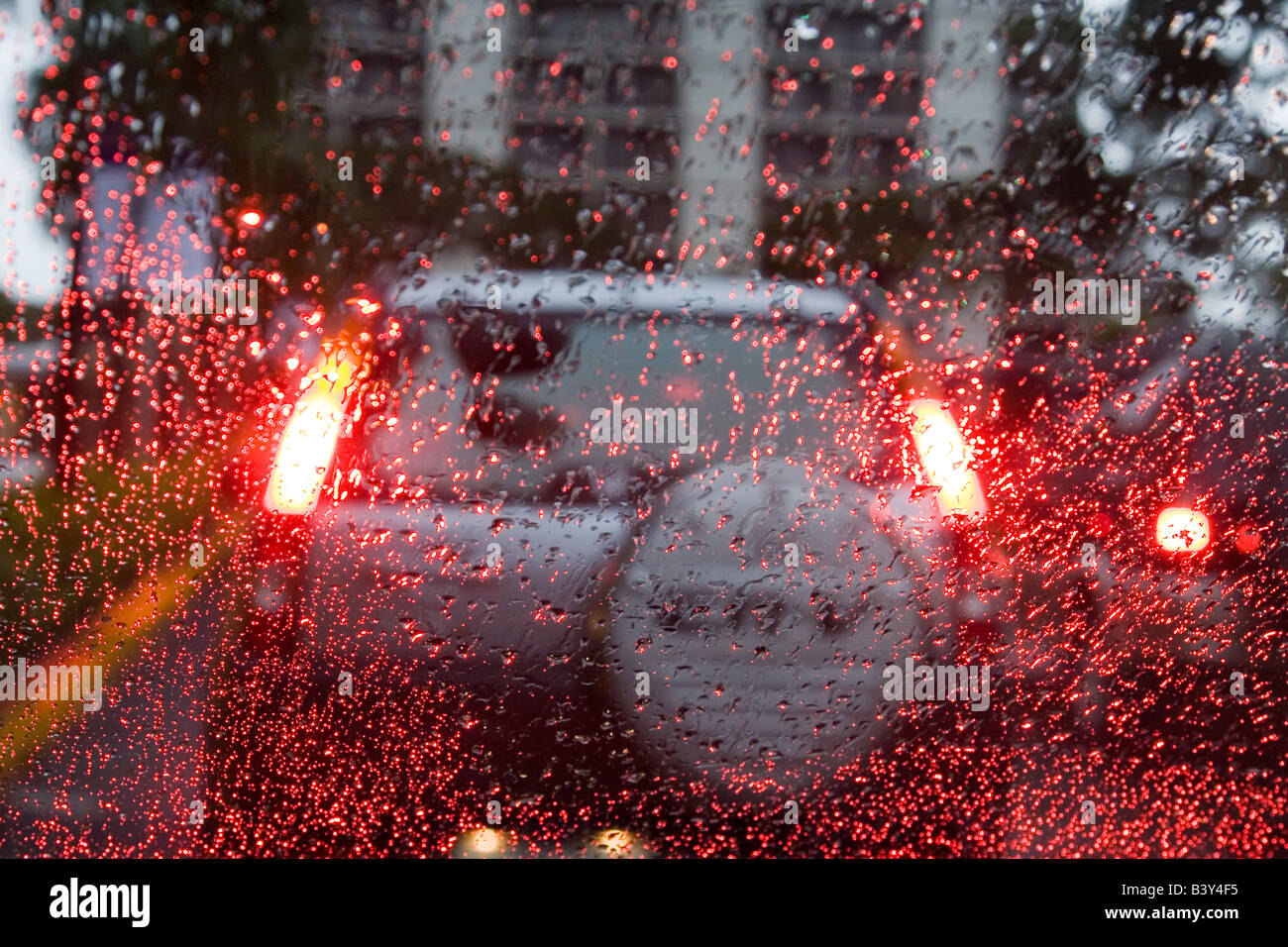 Lights from street cars reflect on a windshield during a rainy day ...