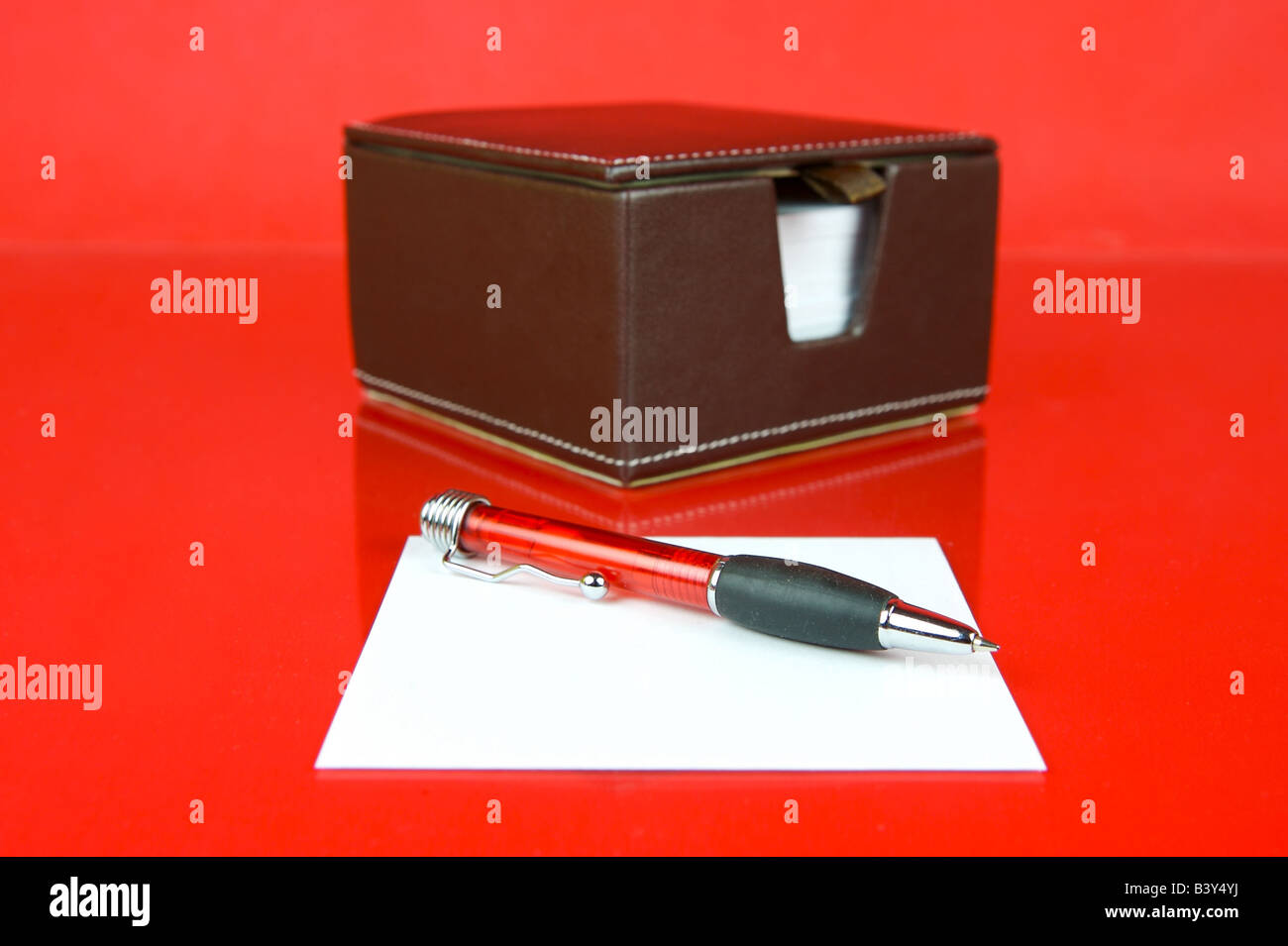 A note block isolated against a red background Stock Photo - Alamy