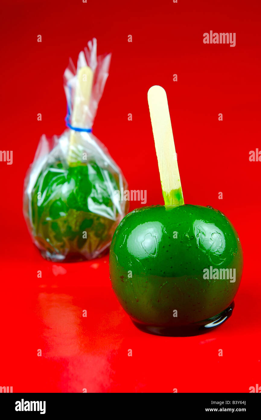 Toffee apples isolated against a red background Stock Photo - Alamy