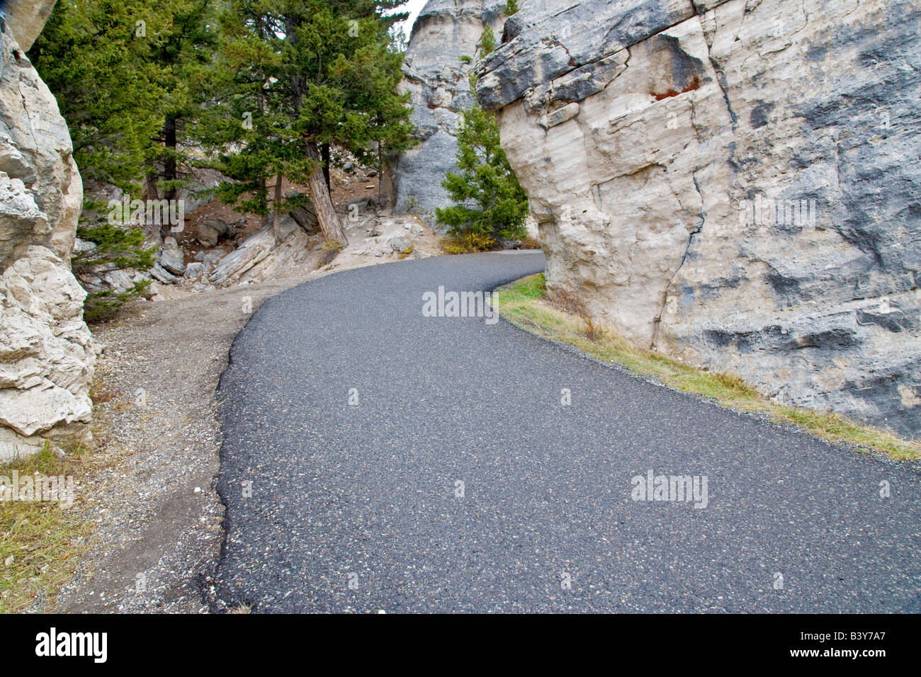 Small paved road in rock outcropping Yellowstone National Park WY Stock ...