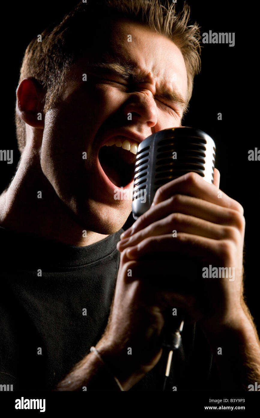 Man singing in a microphone Stock Photo - Alamy
