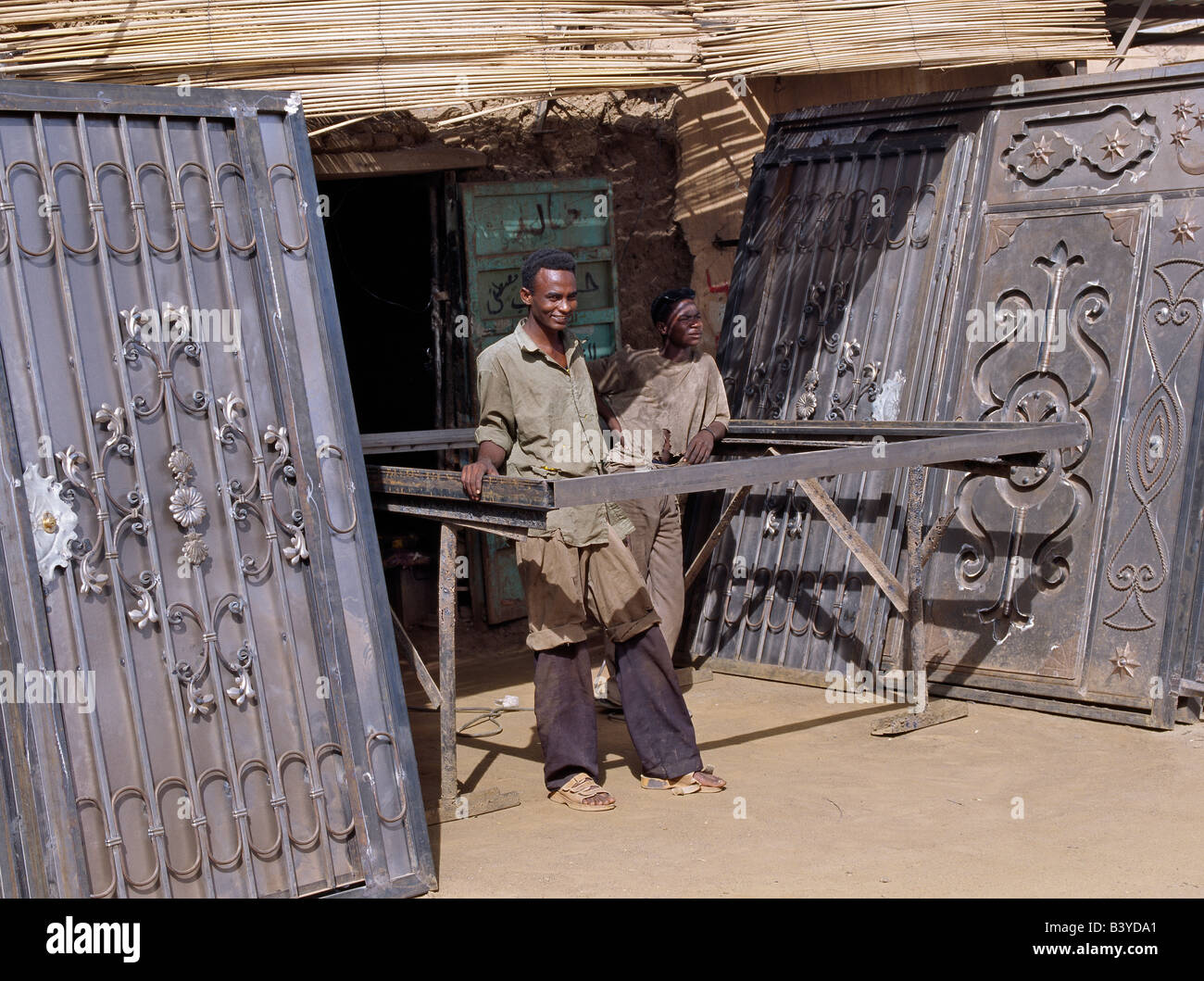 Sudan, Khartoum, Omdurman. Skilled craftsmen pause beside two pairs of ...