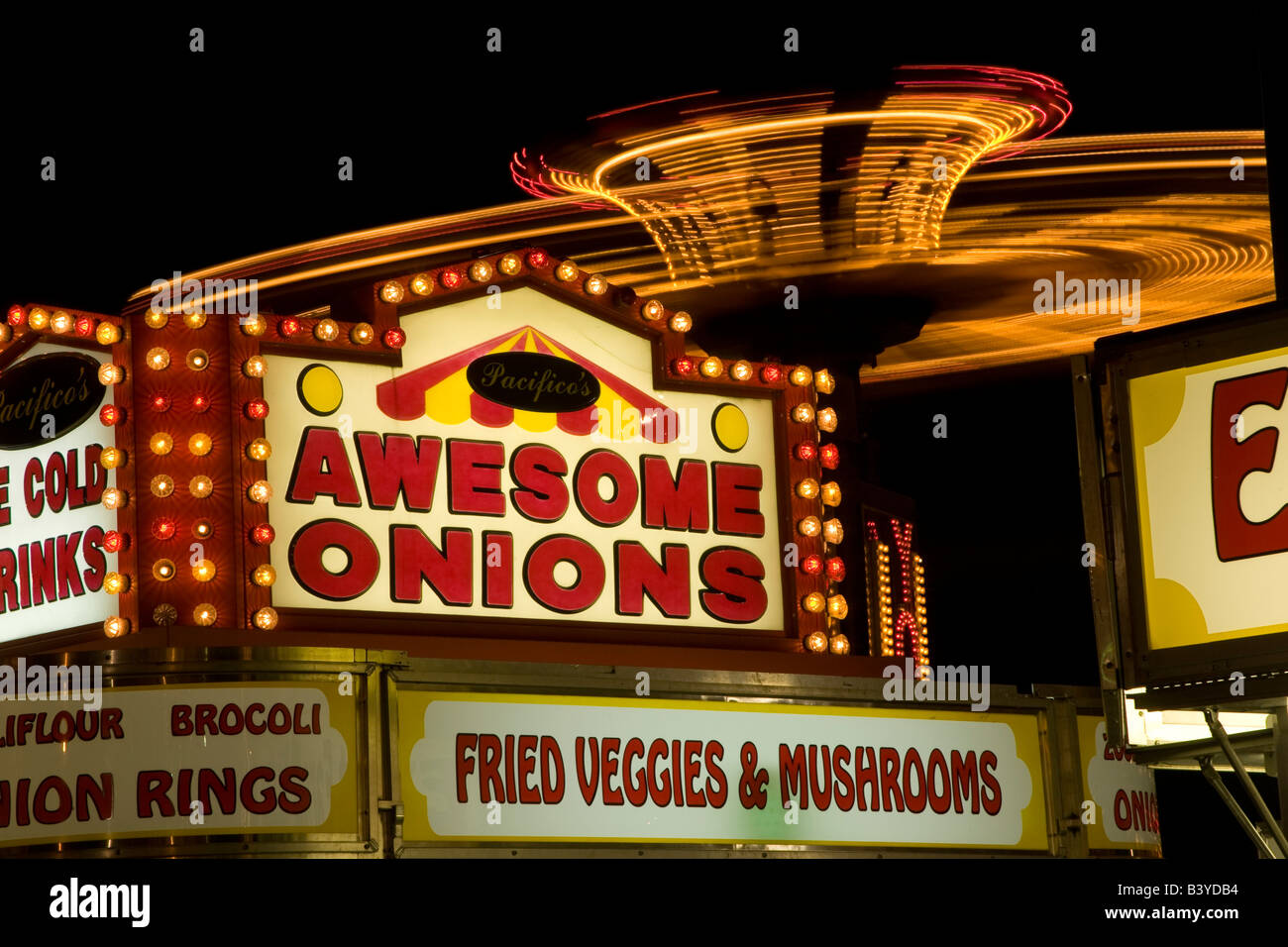 USA, Indiana, Indianapolis. State Fair amusement ride in motion behind ...