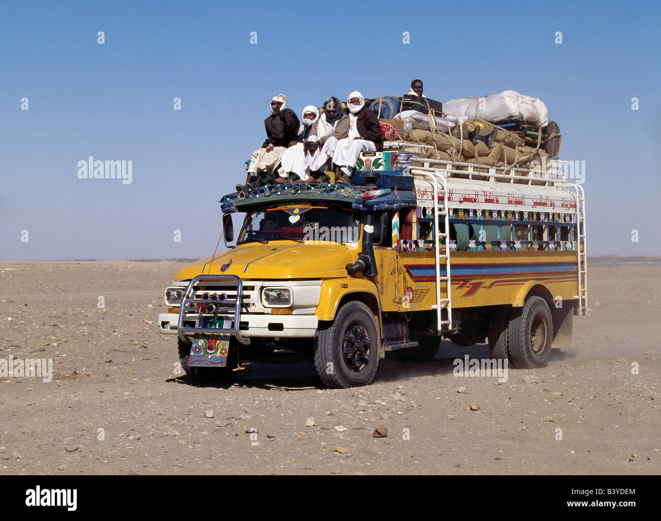 Sudan, Nubian Desert. A heavily-laden bus travels across the Nubian ...