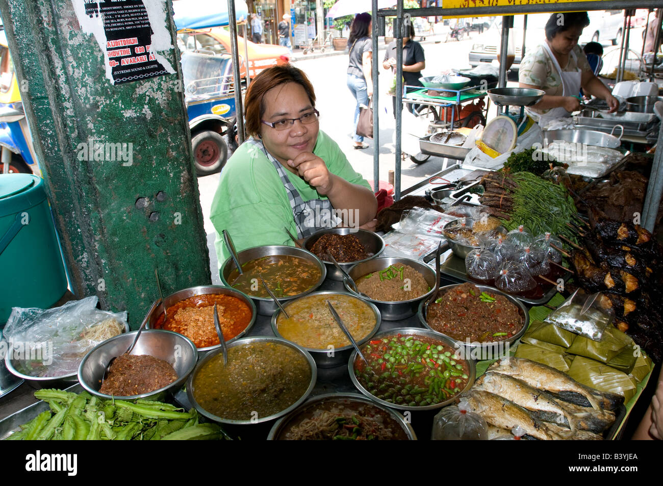 A stall owner sits behind the vast array of curry pastes and curry ...