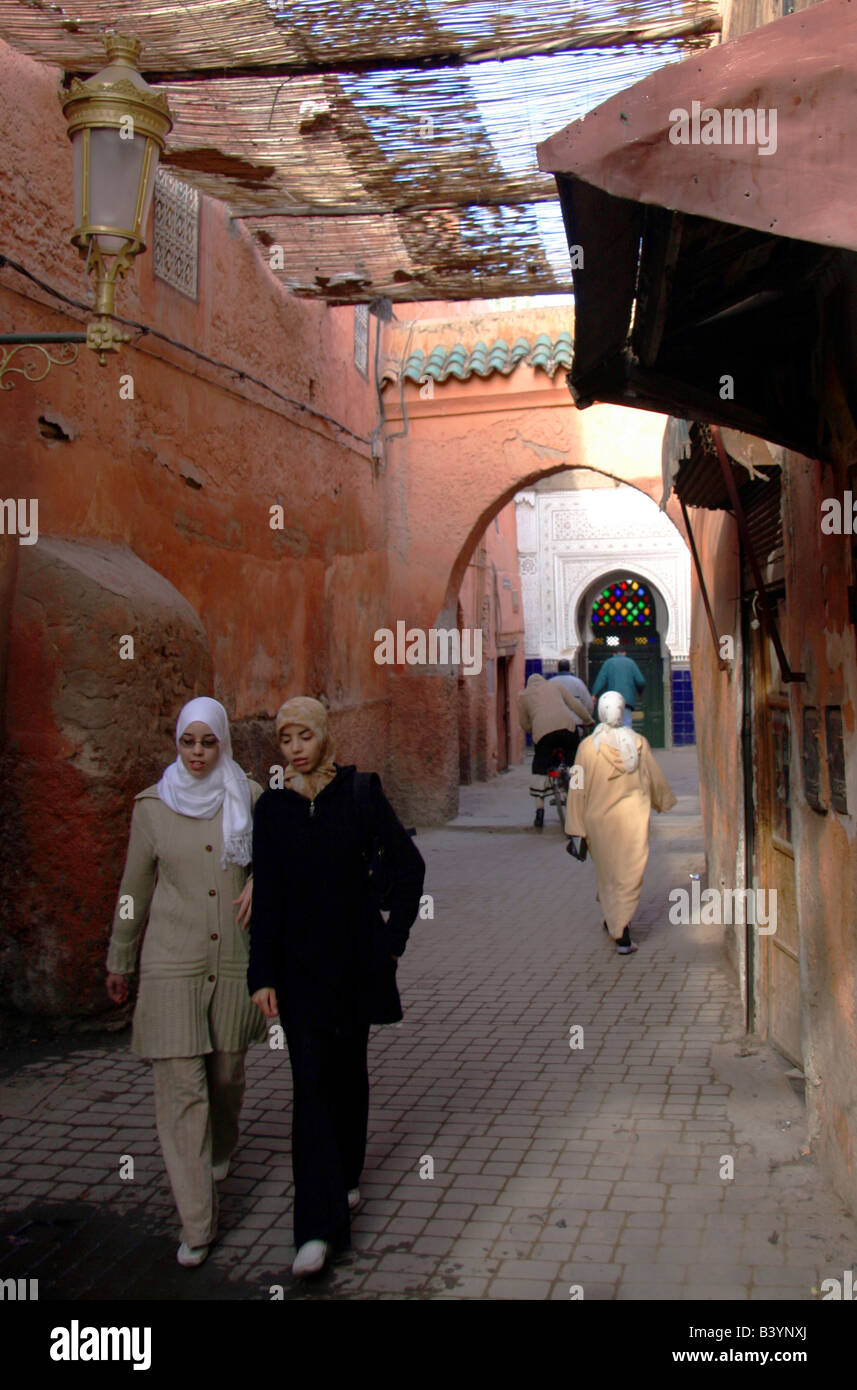 Two muslim girls walking along passageway in Marrakech Morocco Stock ...