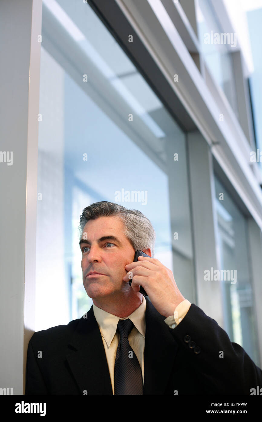 Executive using mobile phone and looking out window in Chicago office ...