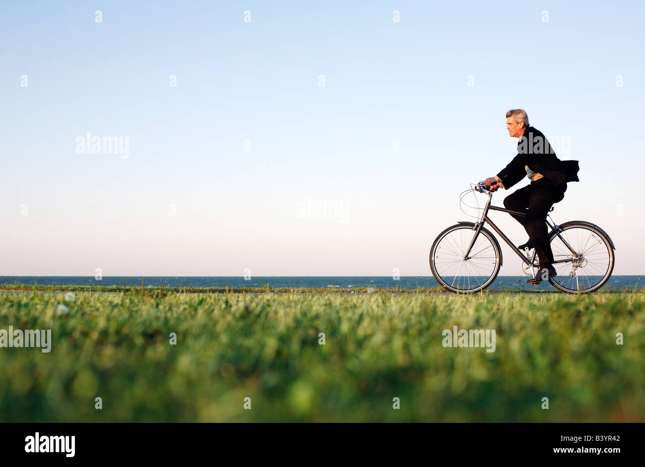 Man riding bike along ocean hi-res stock photography and images - Alamy