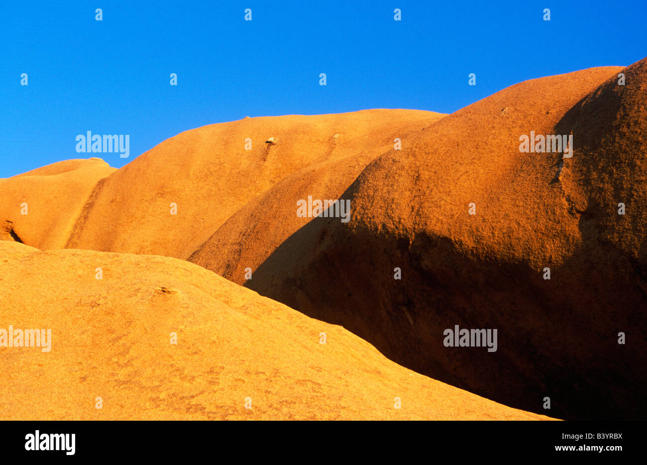 Namibia, Damaraland, Spitzkoppe. Orange red granite cliffs at sunset ...