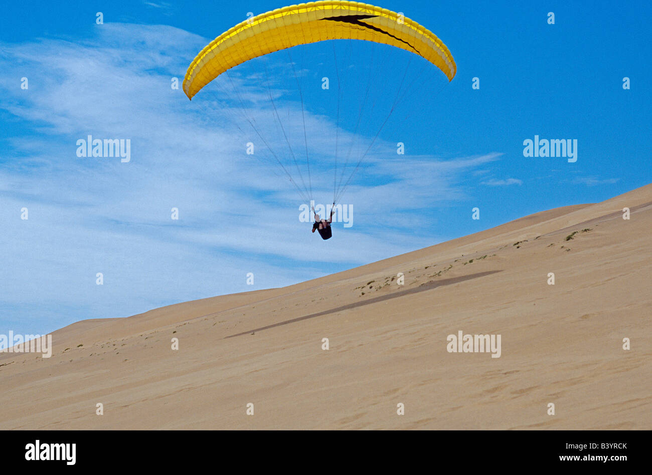 Namibia, Skeleton Coast. Paragliding over the dunes of the Namib Desert ...