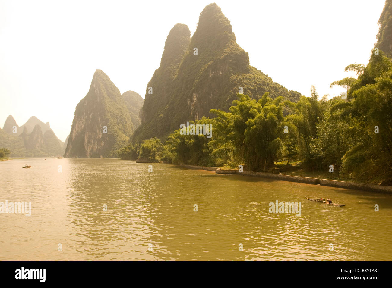 Li River snakes among limestone hills and bamboo forests between Guilin ...