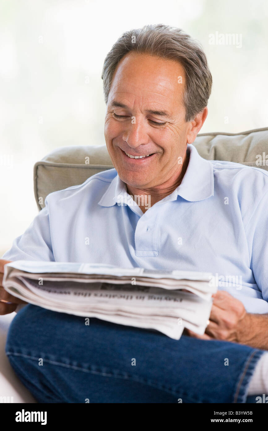 Man relaxing with a newspaper smiling Stock Photo - Alamy