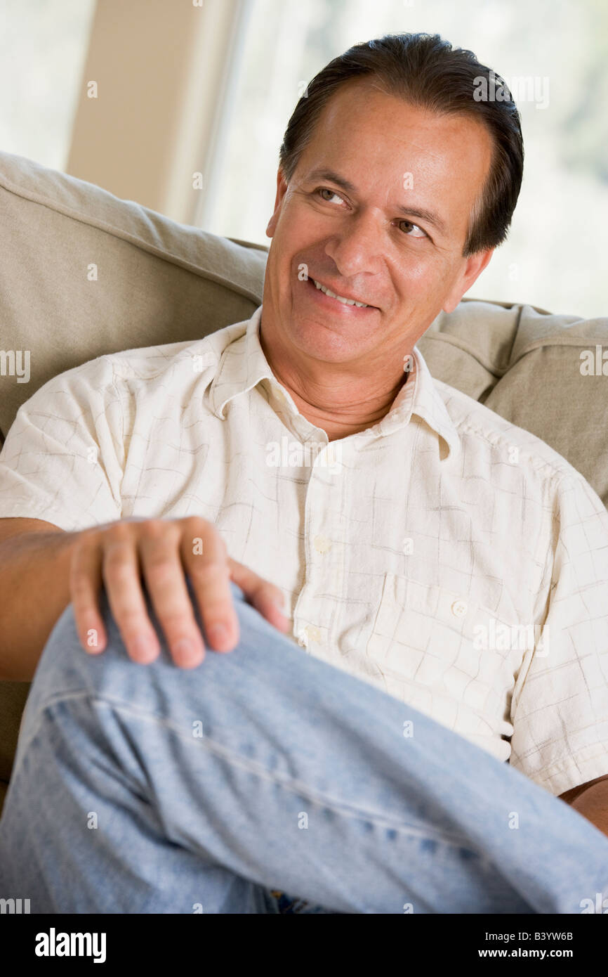 Man sitting in living room smiling Stock Photo - Alamy