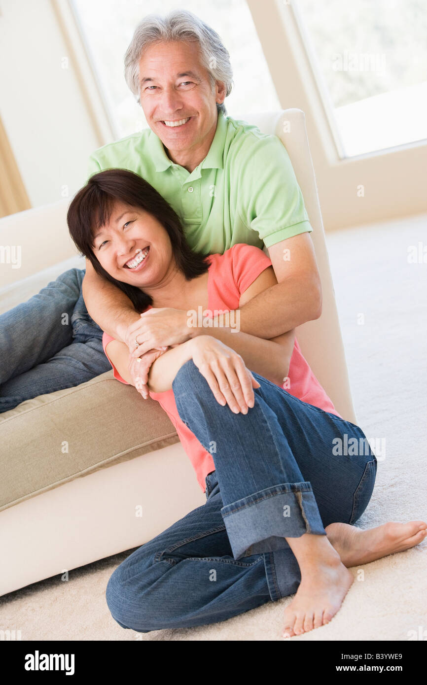 Couple relaxing in living room and smiling Stock Photo - Alamy